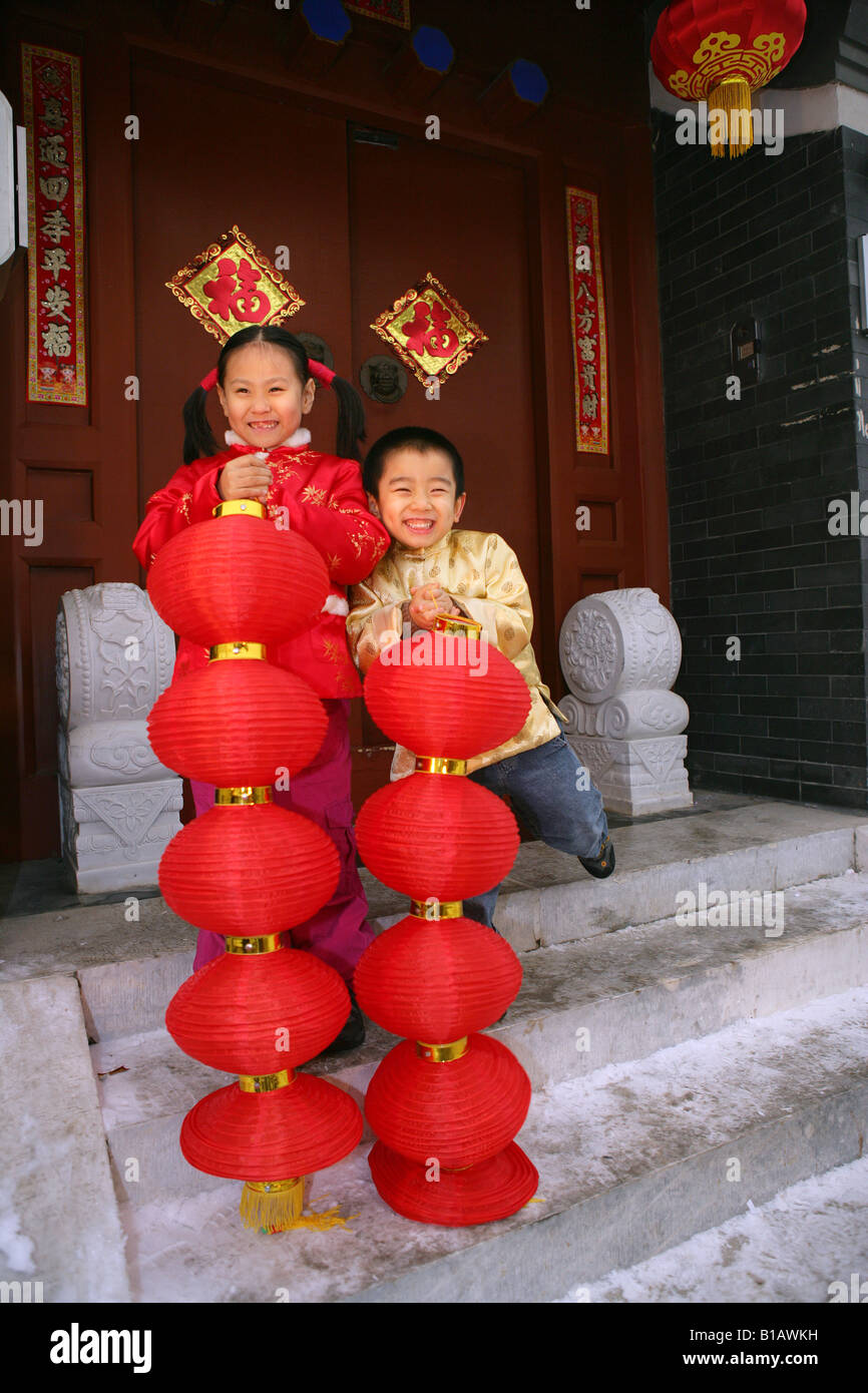 Two children(5-7 years) standing in front of chinese traditional house ...