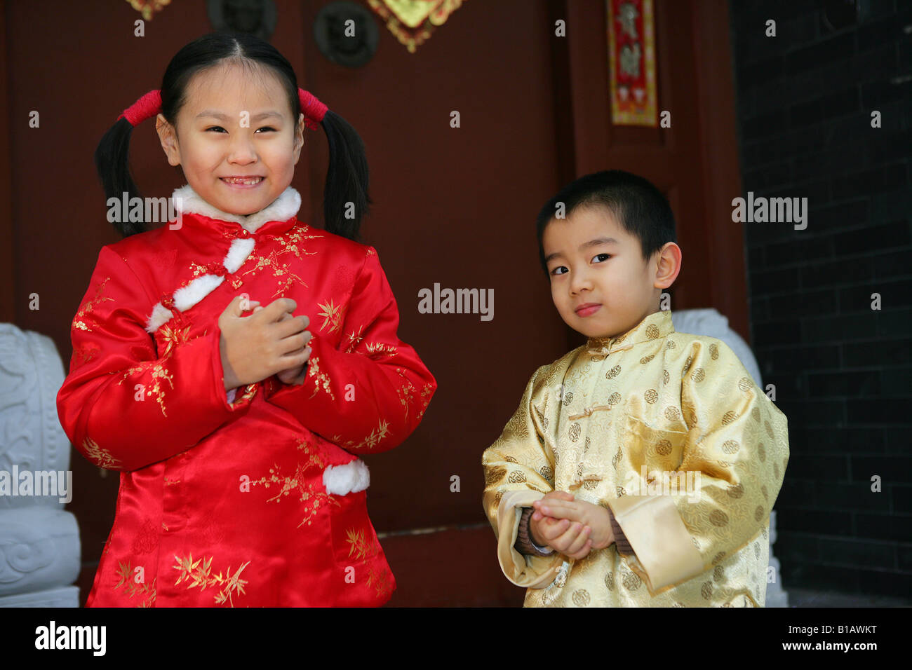 Two children(5-7 years) standing in front of chinese traditional house ...