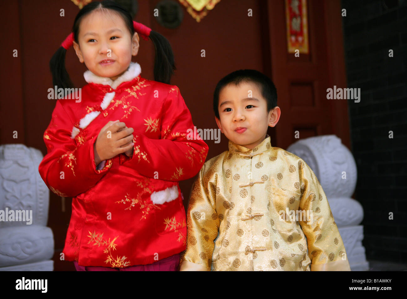 Two children(5-7 years) standing in front of chinese traditional house ...