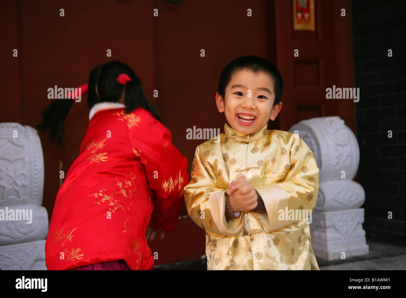 Two children(5-7 years) standing in front of chinese traditional house ...