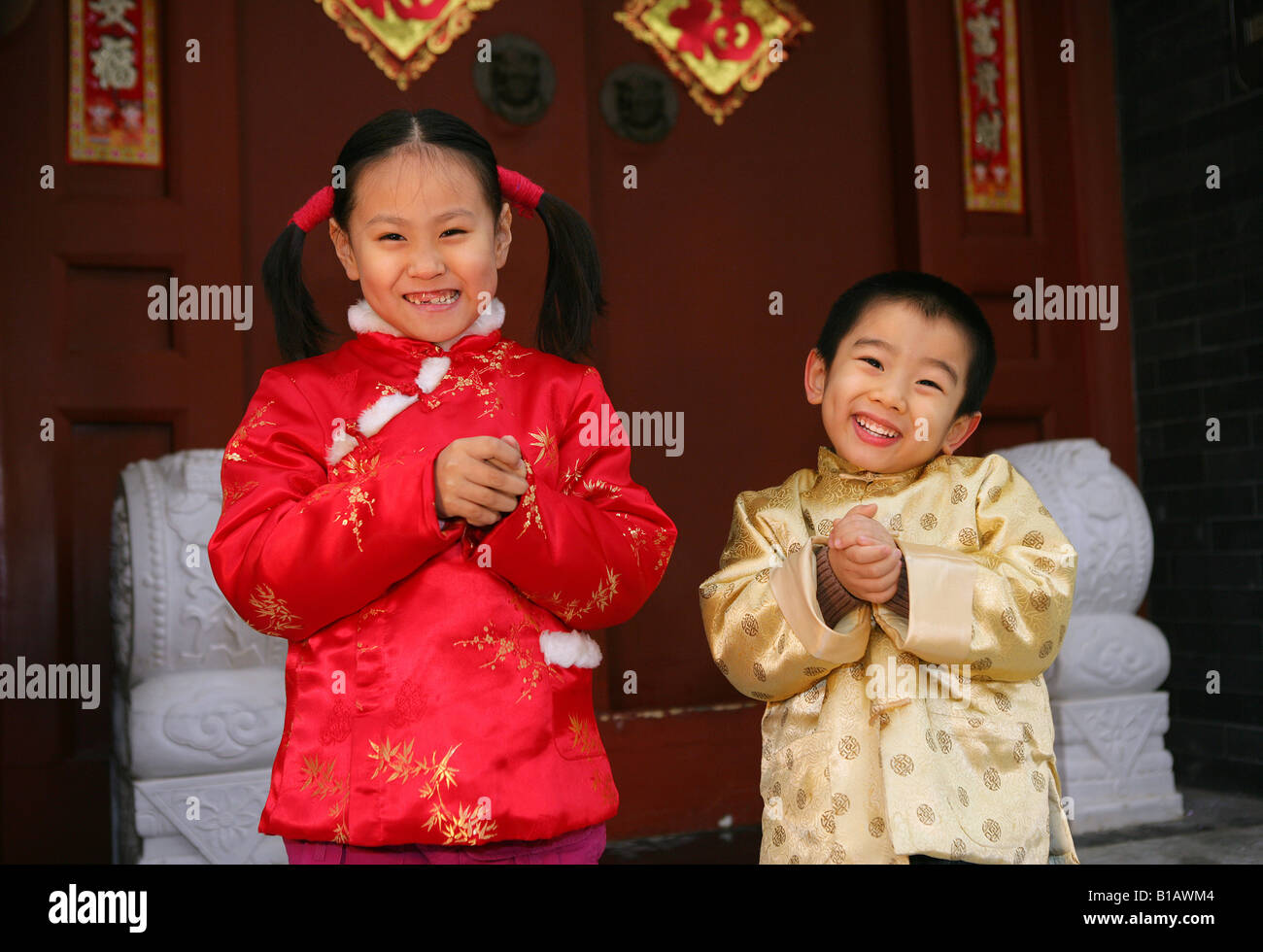 Two children(5-7 years) standing in front of chinese traditional house ...