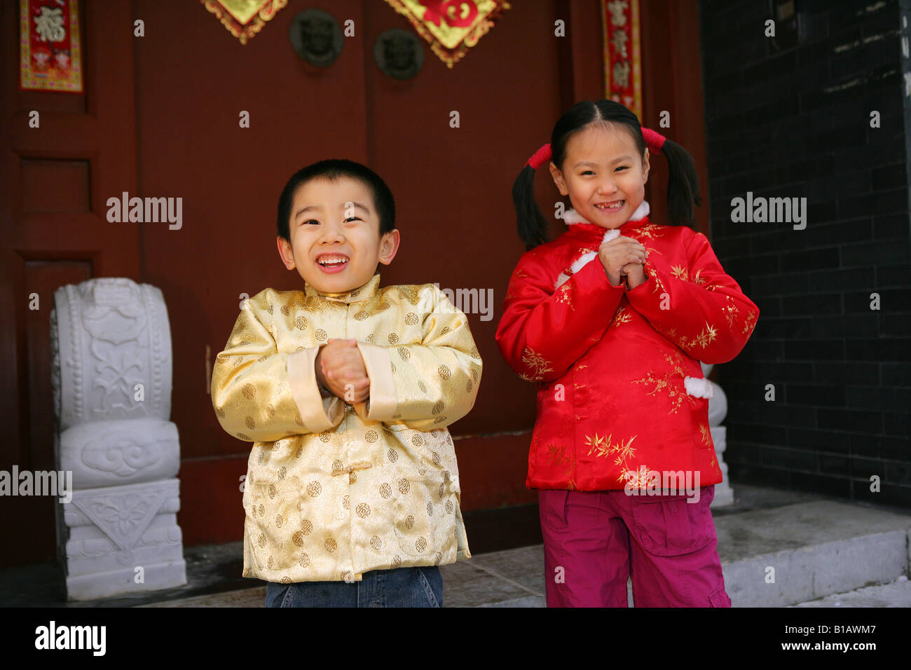 Two children(5-7 years) standing in front of chinese traditional house ...
