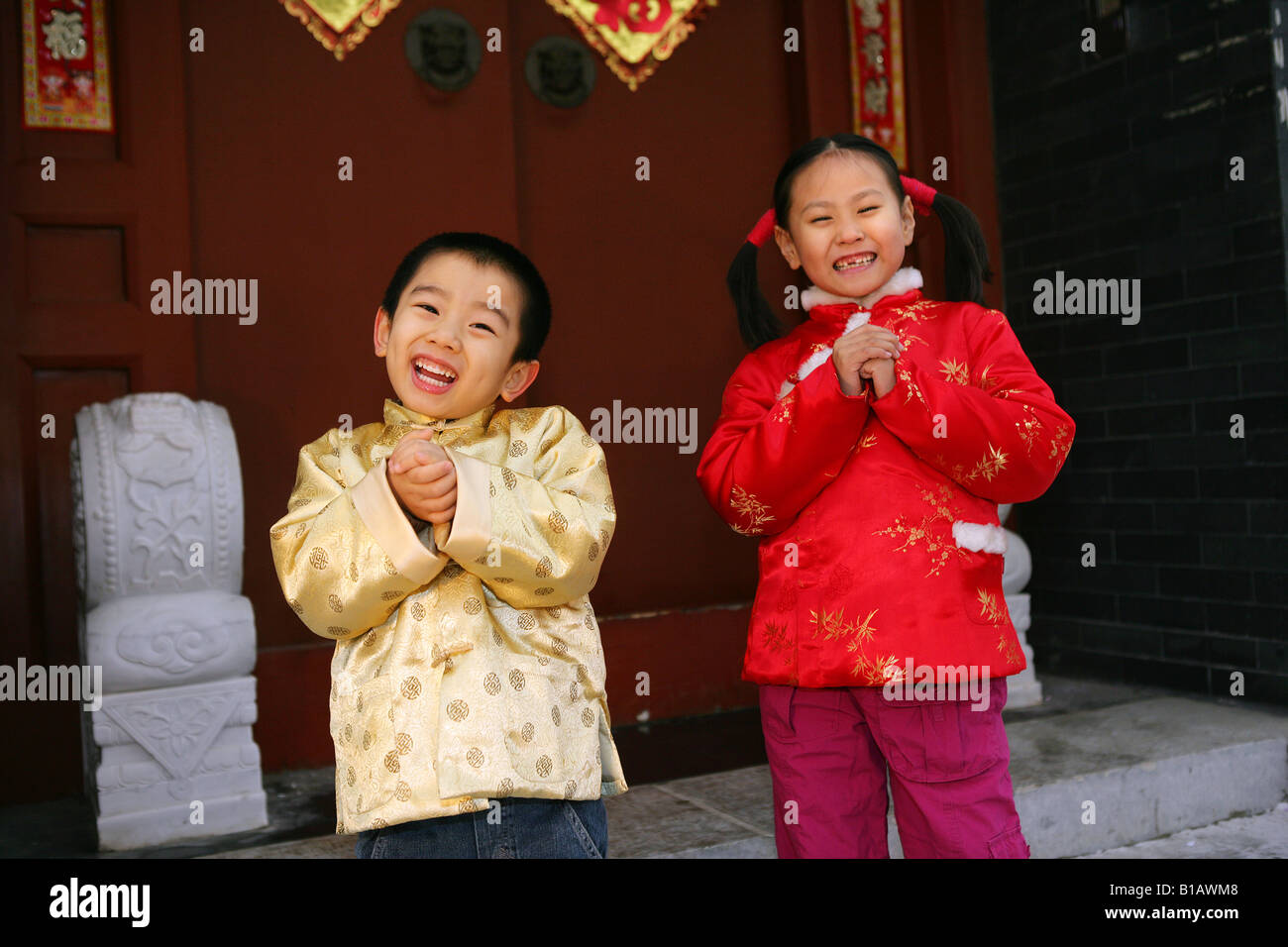 Two children(5-7 years) standing in front of chinese traditional house ...