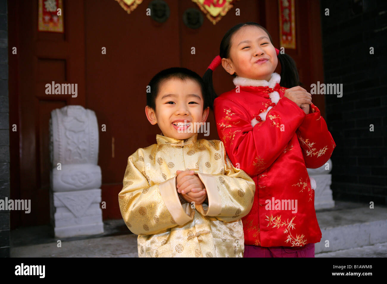 Two children(5-7 years) standing in front of chinese traditional house ...