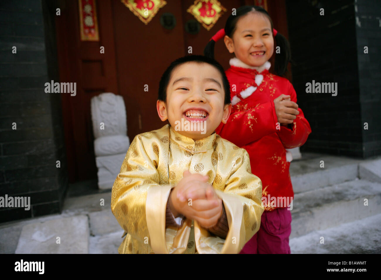 Two children(5-7 years) standing in front of chinese traditional house ...