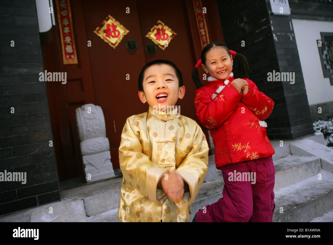 Two children(5-7 years) standing in front of chinese traditional house ...