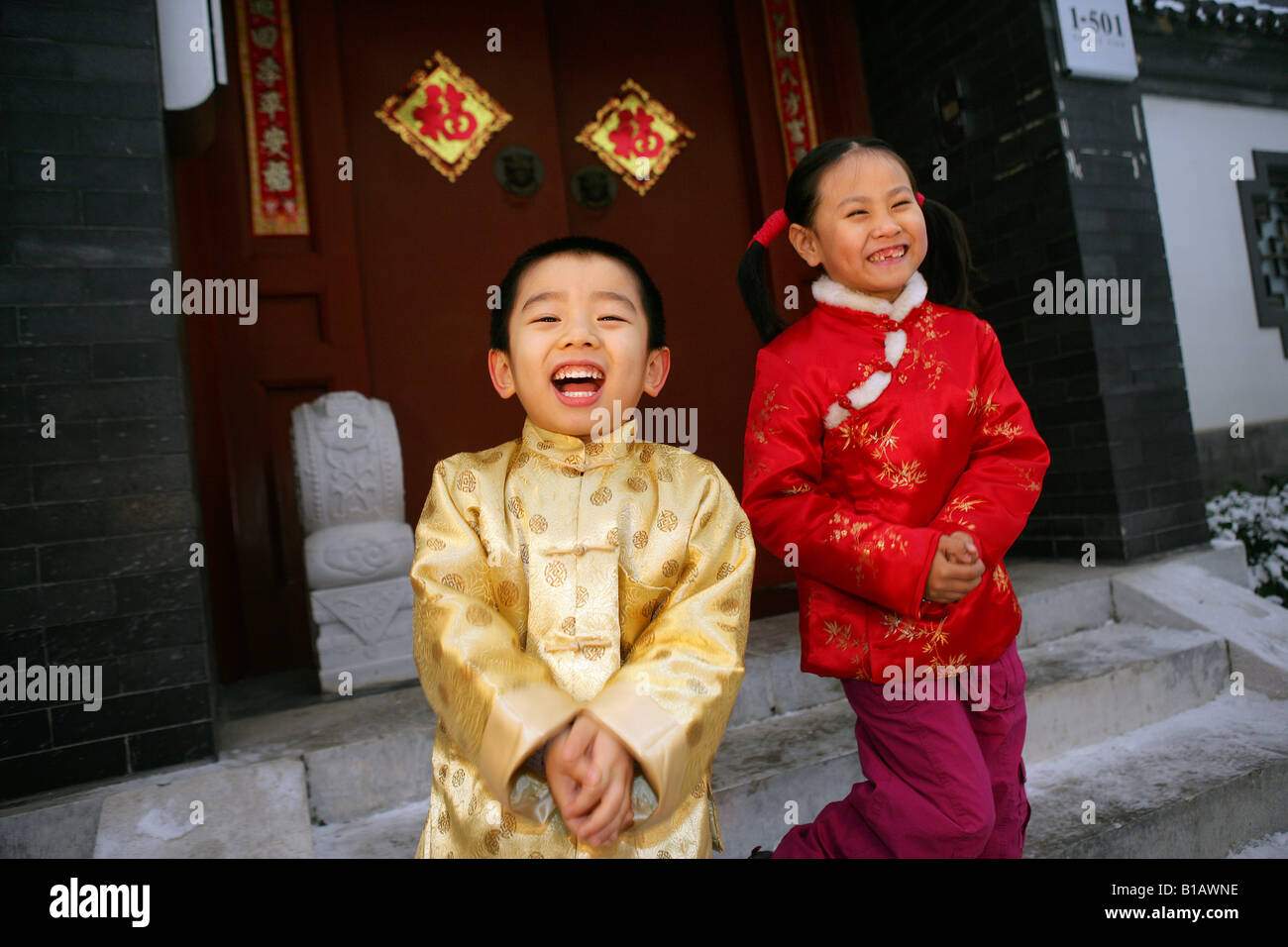 Two children(5-7 years) standing in front of chinese traditional house ...