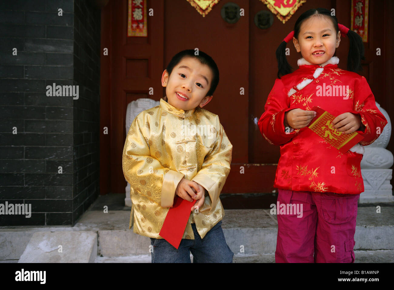 Two children(5-7 years) standing in front of chinese traditional house ...