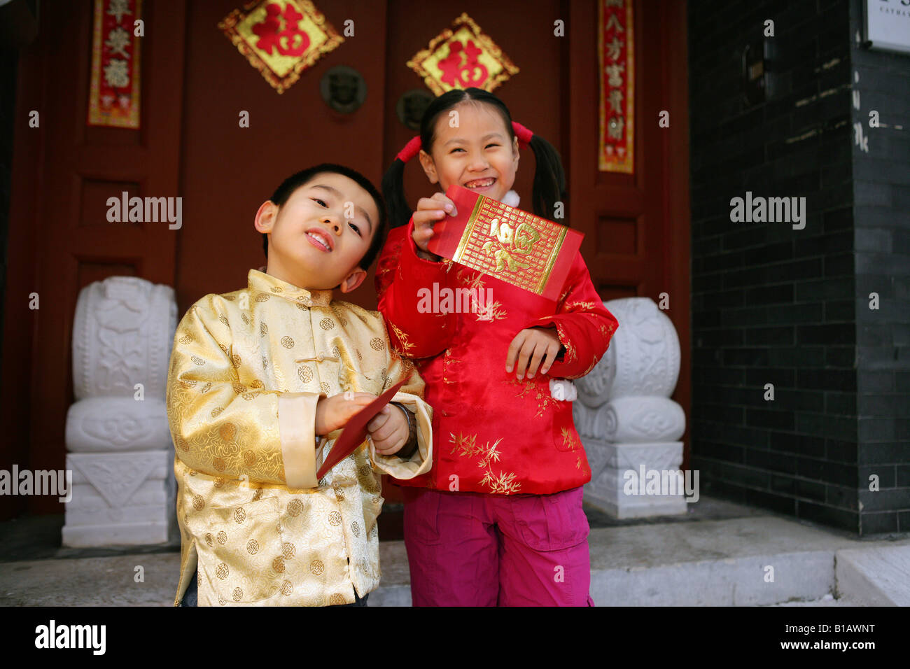 Two children(5-7 years) standing in front of chinese traditional house ...