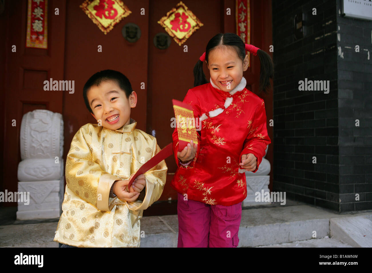 Two children(5-7 years) standing in front of chinese traditional house ...