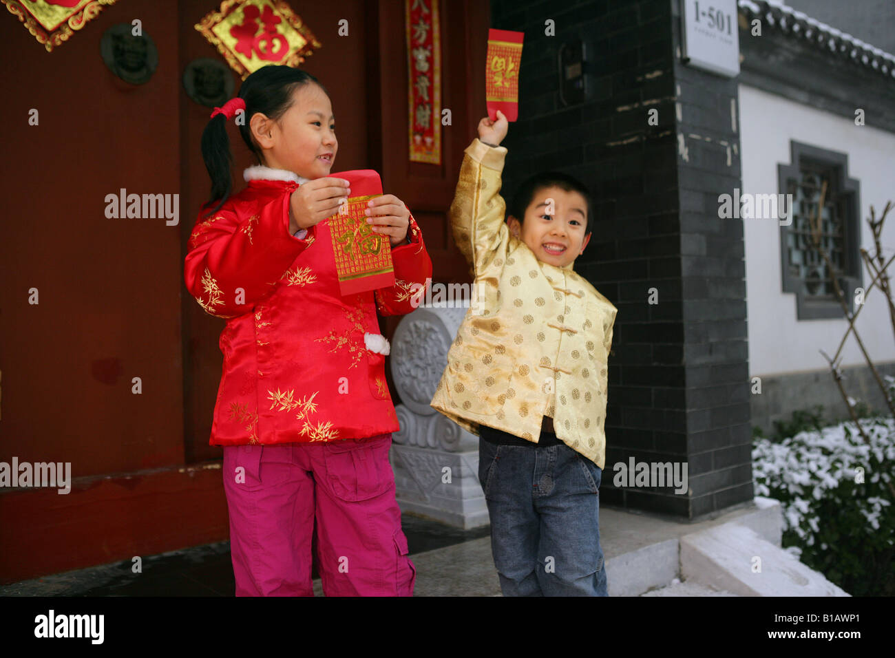 Two children(5-7 years) standing in front of chinese traditional house ...