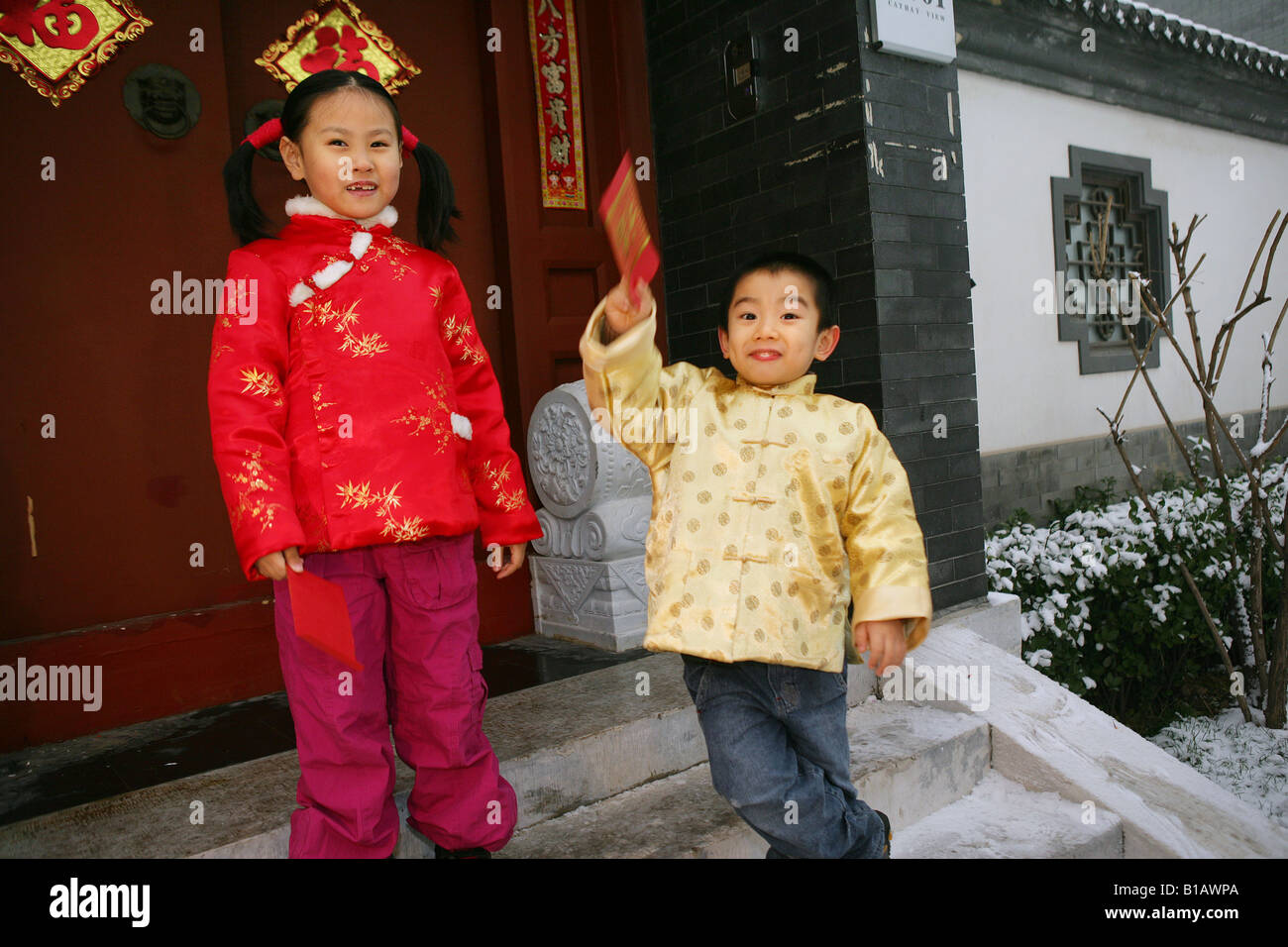 Two children(5-7 years) standing in front of chinese traditional house ...