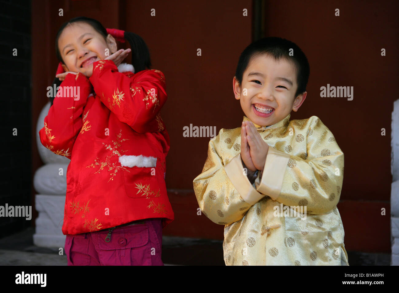 Two children(5-7 years) standing in front of chinese traditional house ...