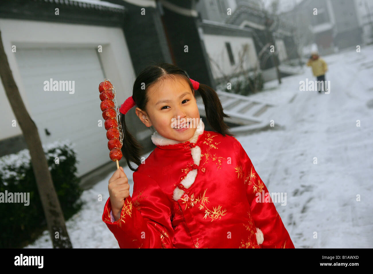 one chinese girl dressed in traditional clothing holding candied haws ...