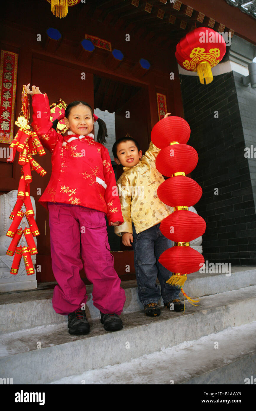 Two children(5-7 years) standing in front of chinese traditional house ...