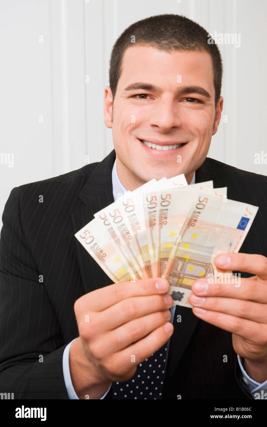 Young man holding euro banknotes, portrait Stock Photo - Alamy