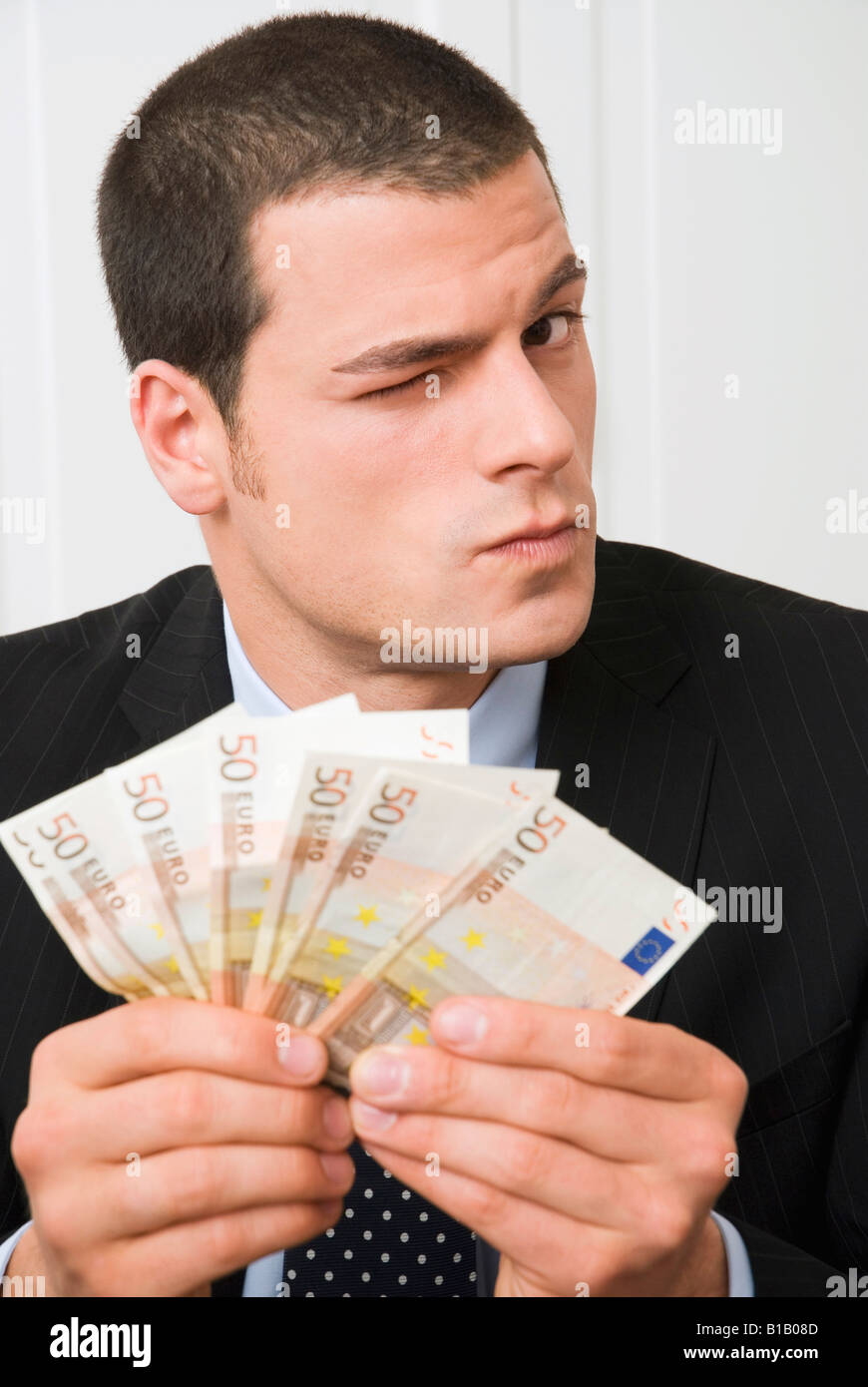 Young man holding euro banknotes, portrait Stock Photo - Alamy