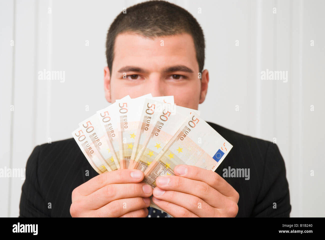 Young man holding euro banknotes, portrait Stock Photo - Alamy