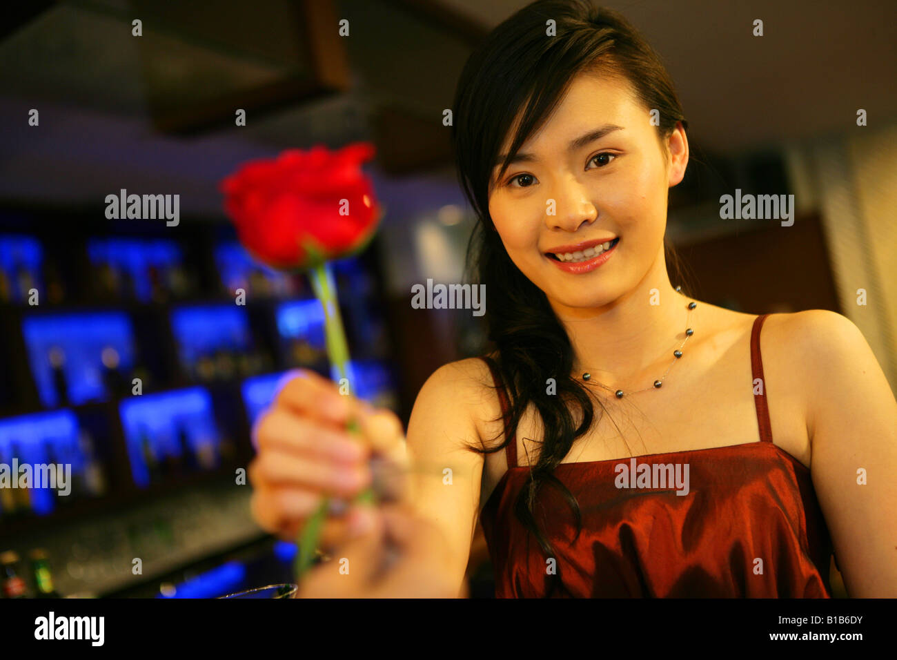 young woman receiving rose in bar of hotel Stock Photo - Alamy