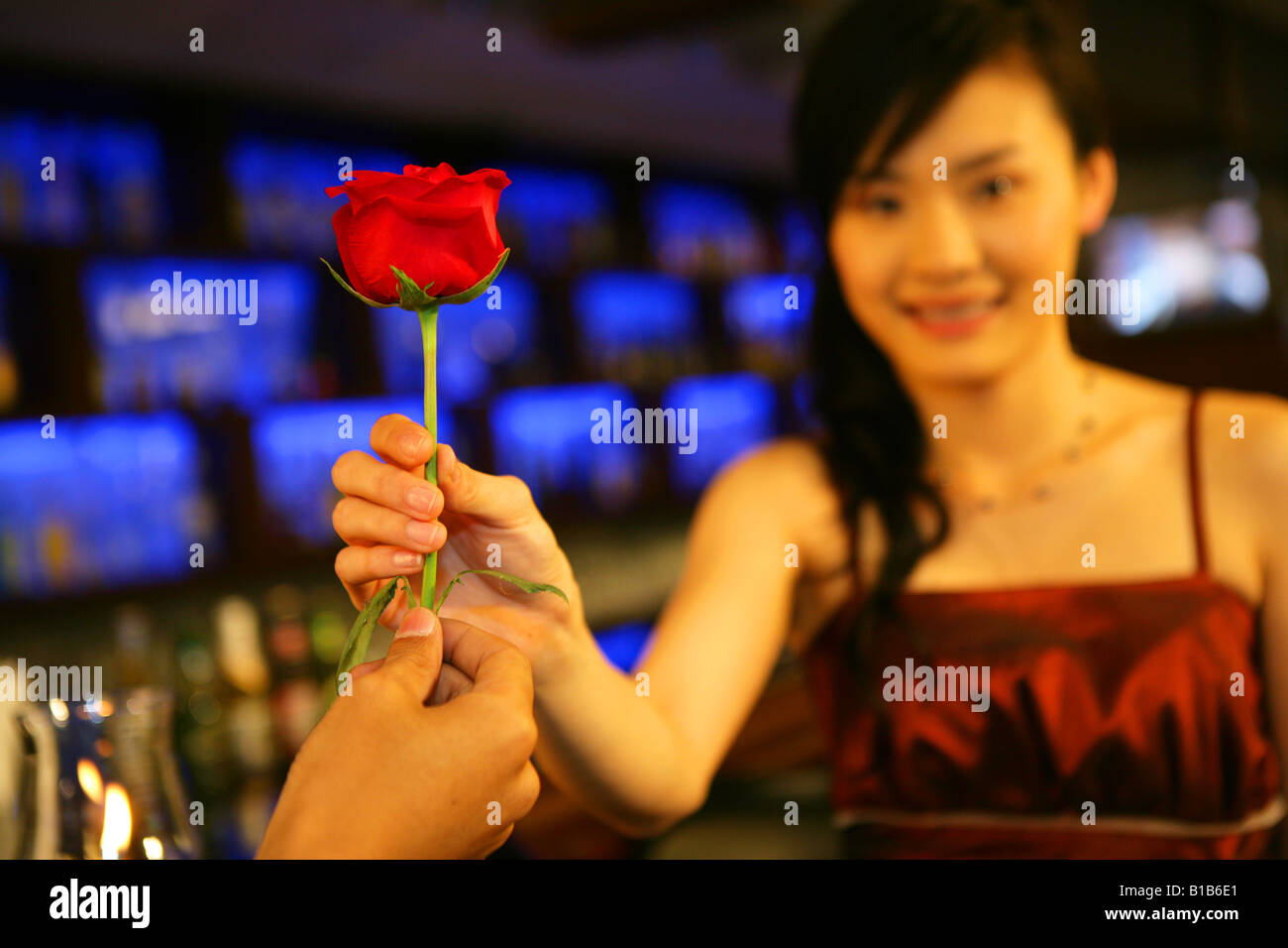 young woman receiving rose in bar of hotel Stock Photo - Alamy