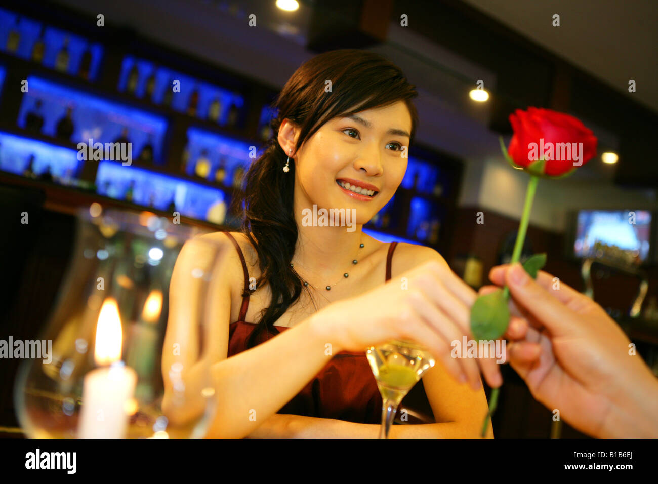young woman receiving rose in bar of hotel Stock Photo - Alamy