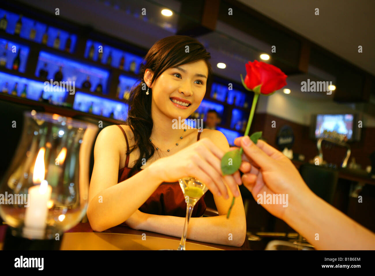 young woman receiving rose in bar of hotel Stock Photo - Alamy