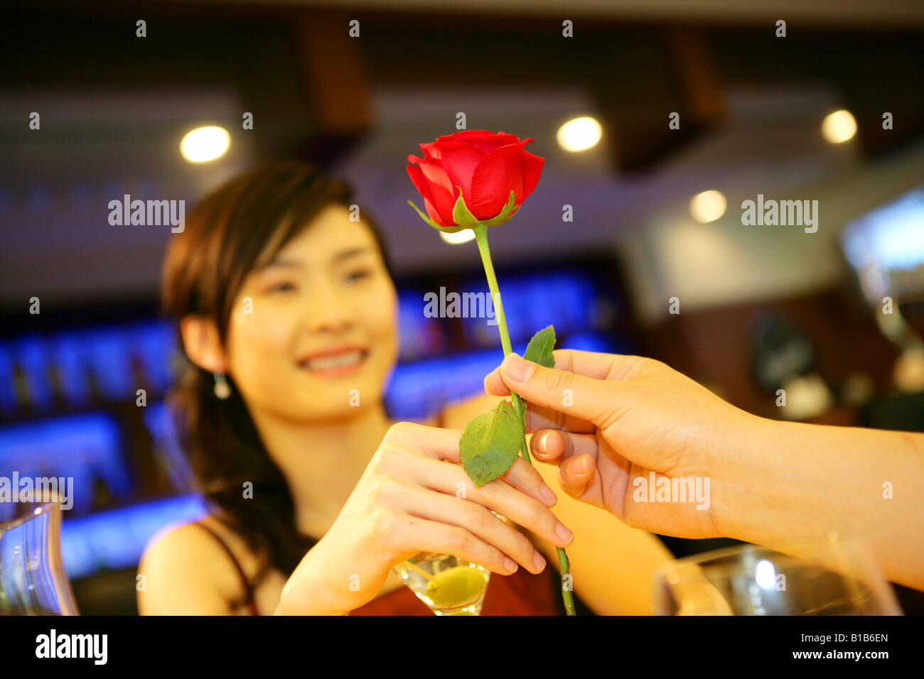 young woman receiving rose in bar of hotel Stock Photo - Alamy