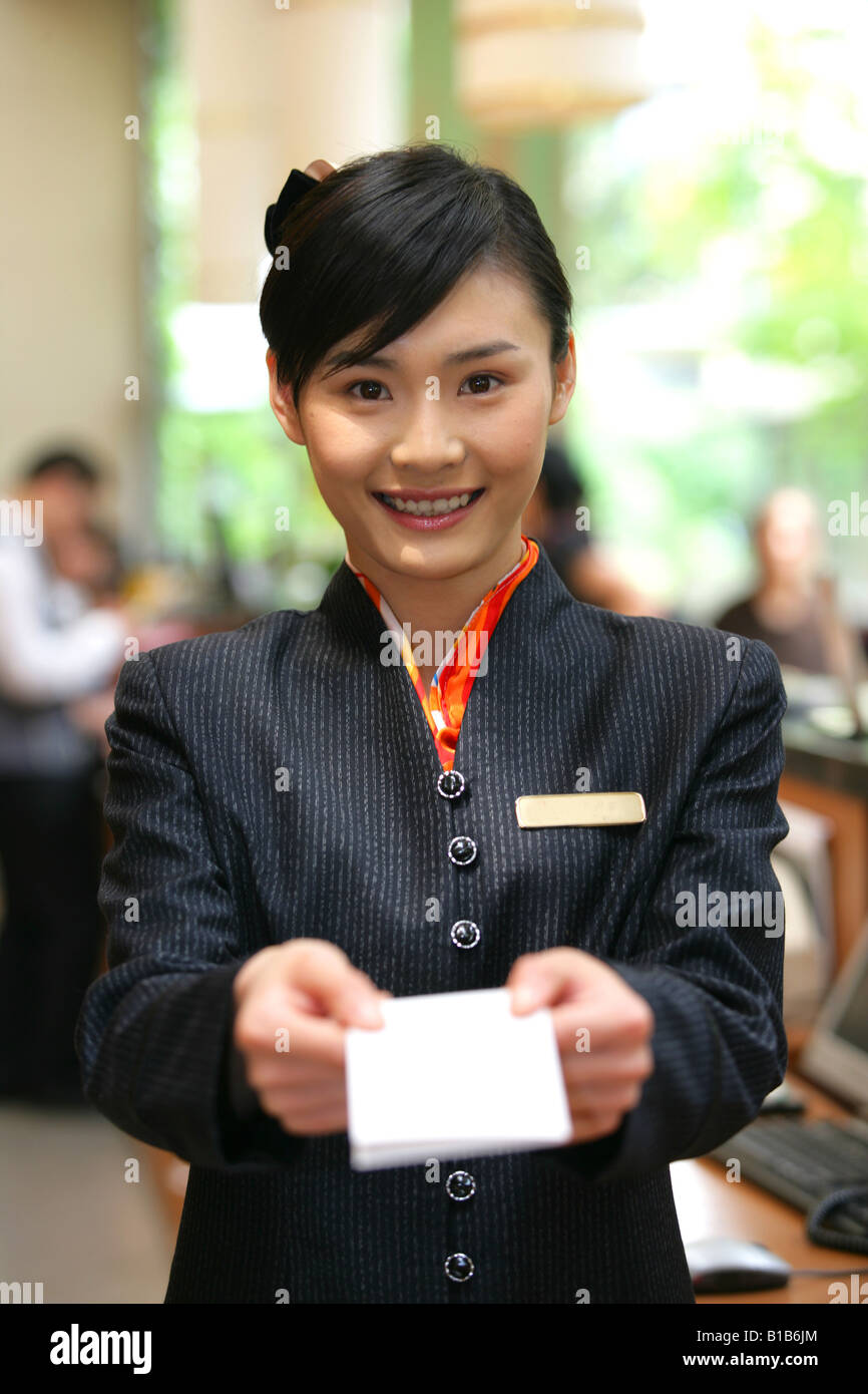 hotel receptionist passing business card Stock Photo - Alamy