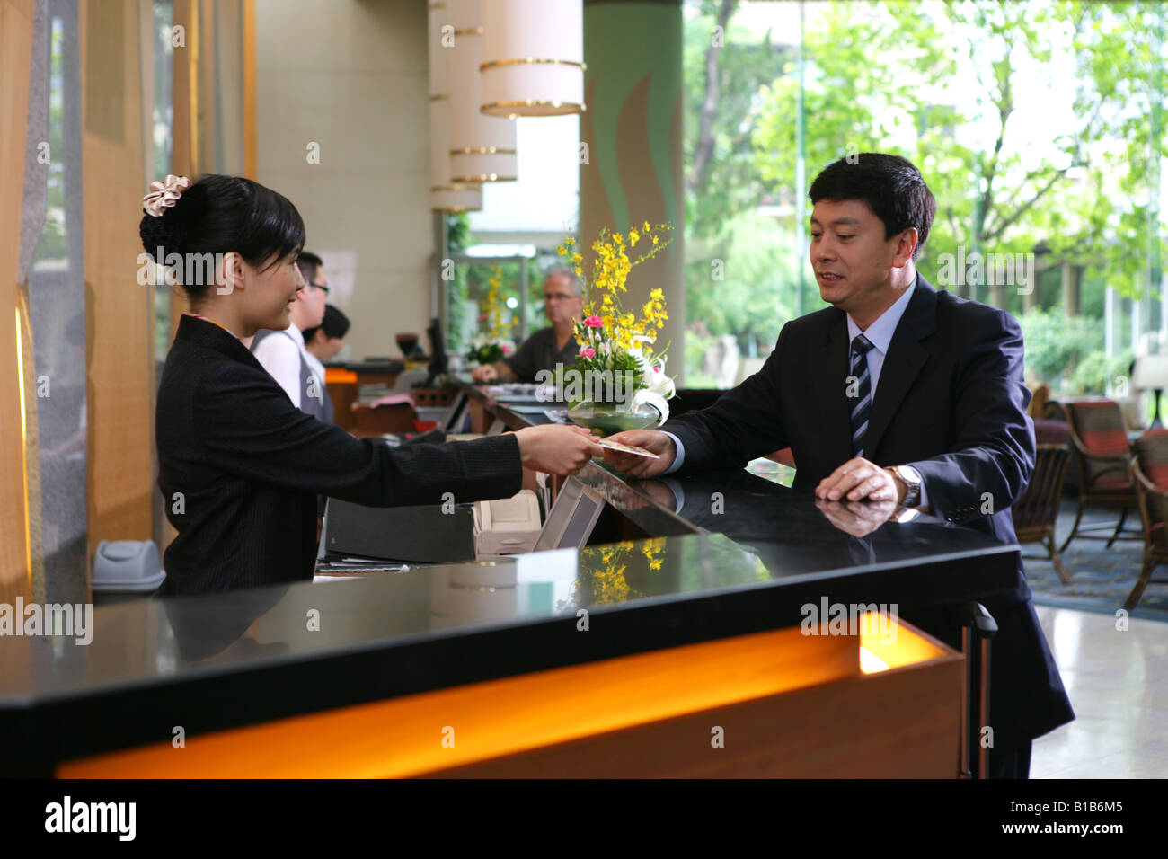 businessman standing at hotel reception Stock Photo - Alamy