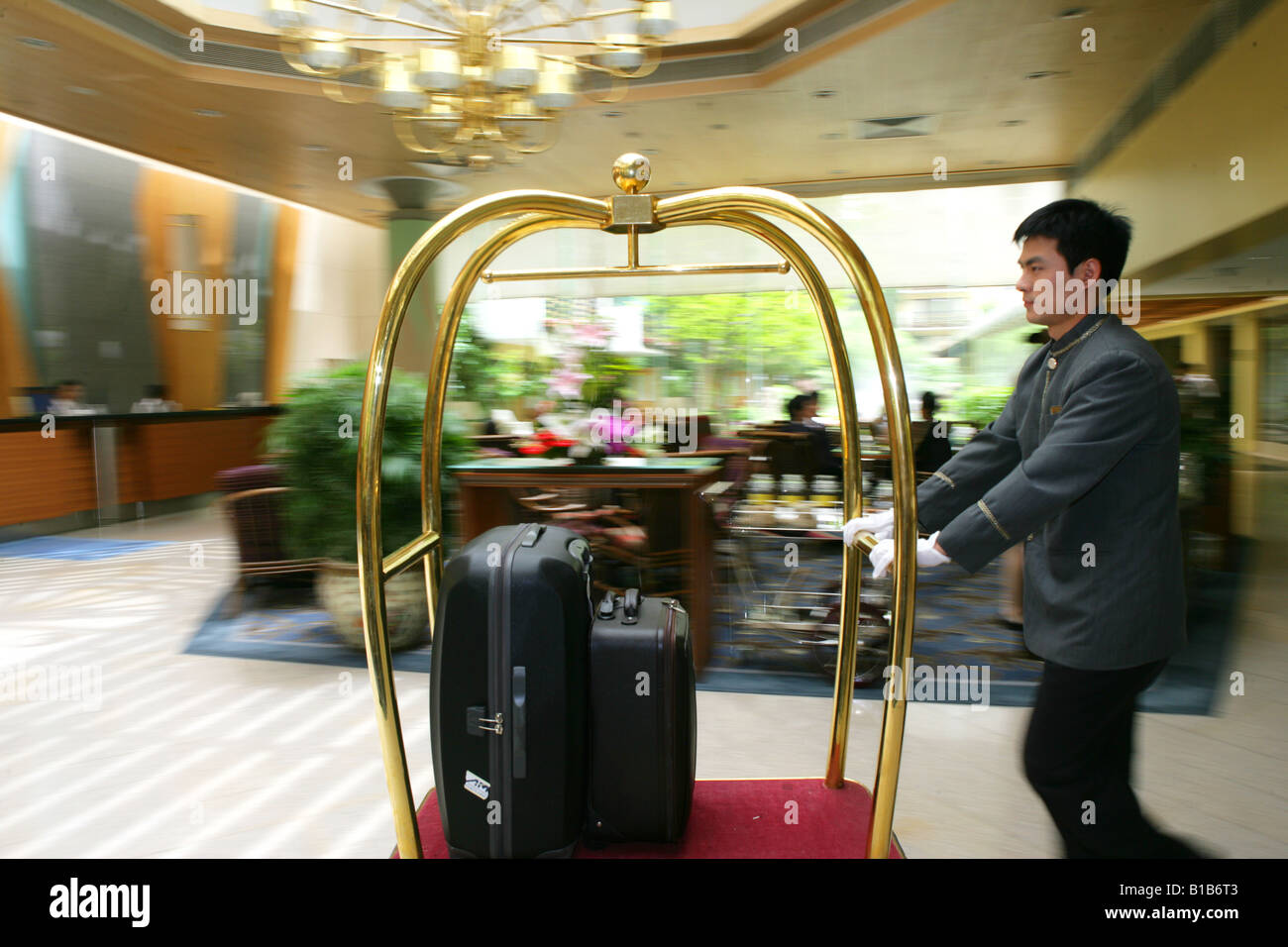 bellhop pushing luggage cart Stock Photo - Alamy
