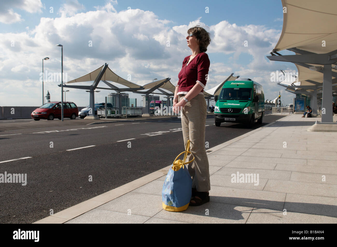 Lady waiting for transport by arrivals London Heathrow Airport Terminal ...