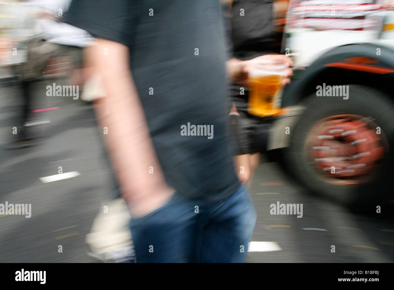 man carrying beer glass in street Stock Photo - Alamy