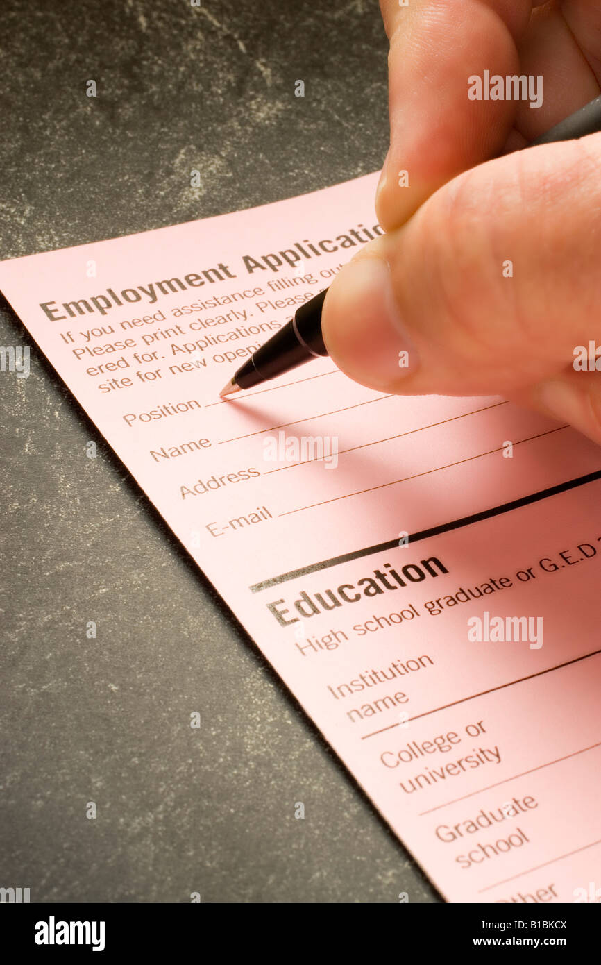 Mans hand filling out an employment application with a ballpoint pen ...