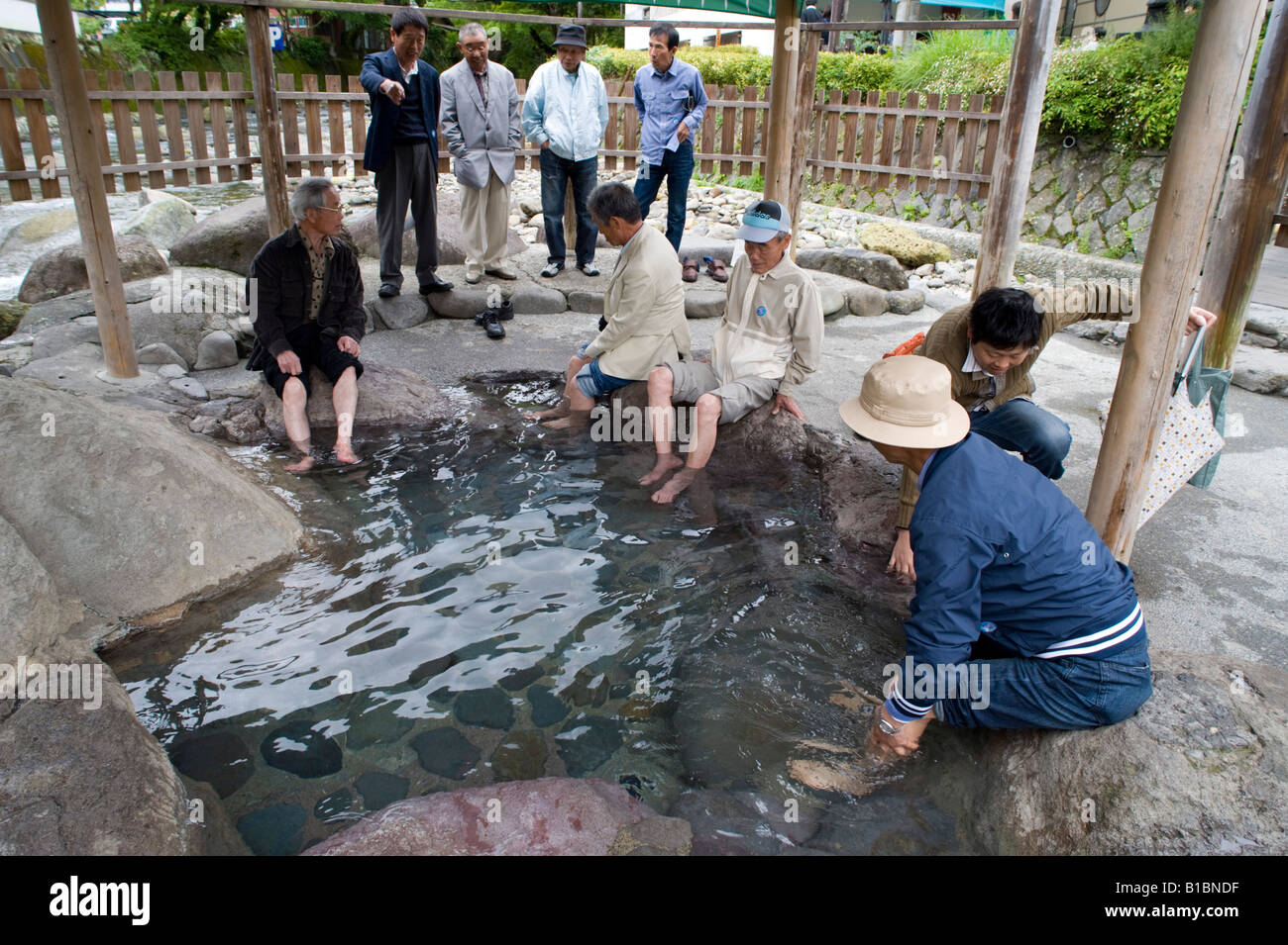 Men bathing feet in hot water outdoor onsen at Shuzenji in Izu ...