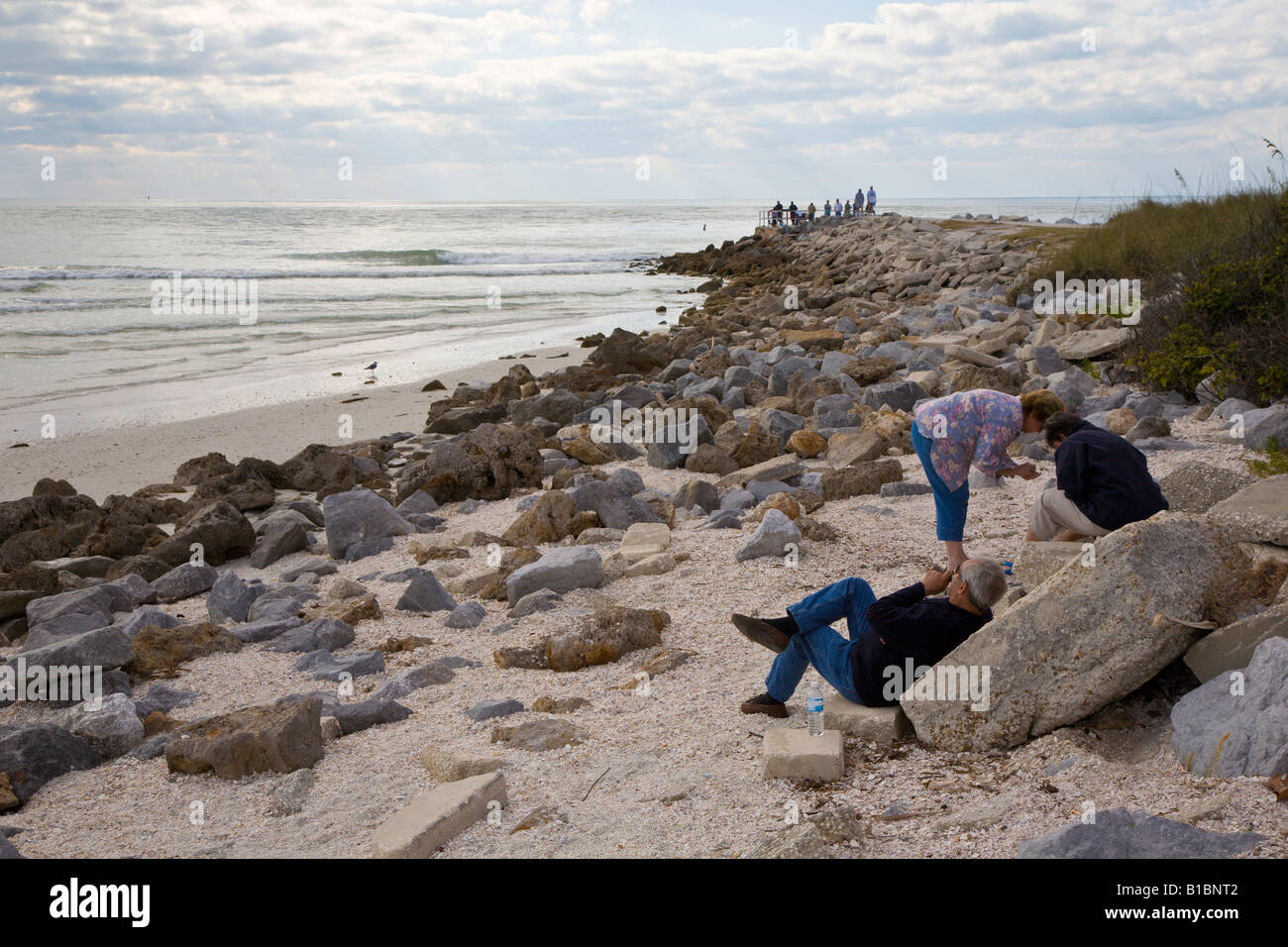 Visitors relax and look for shells on rocky beach at Long Key, Florida ...