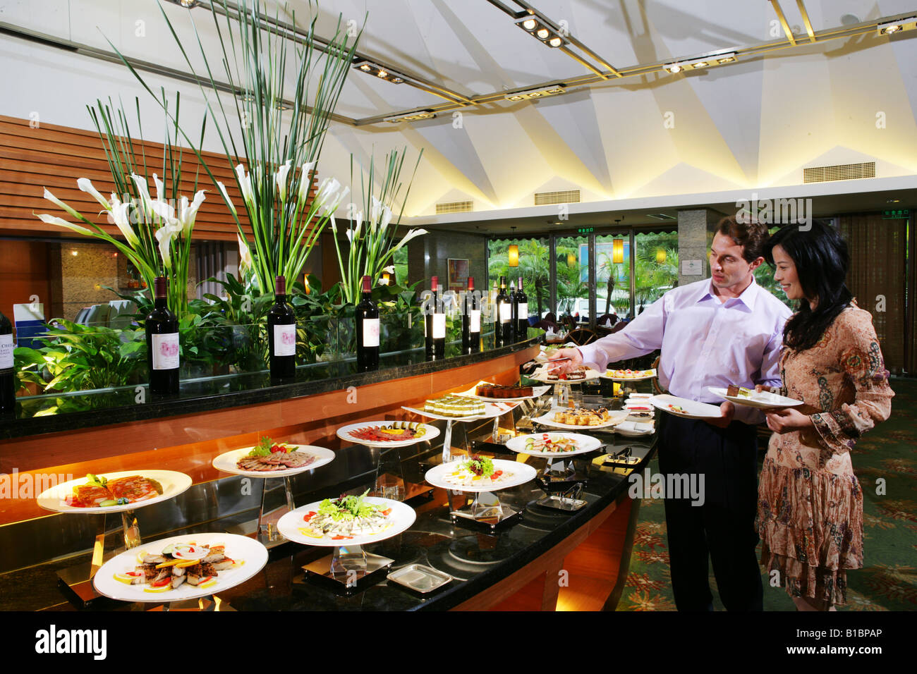 two guests from different cultures taking food in hotel restaurant ...