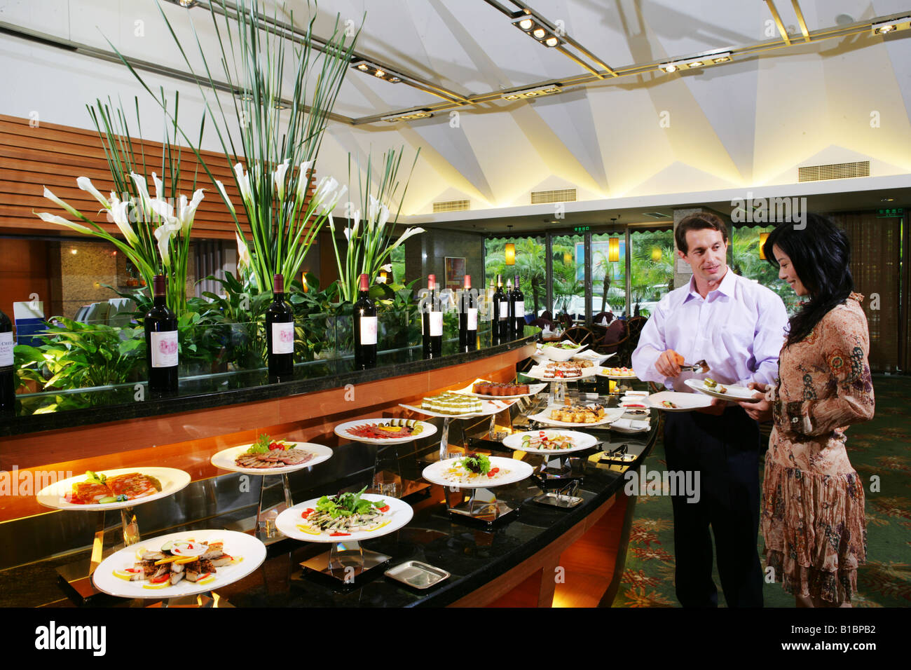 two guests from different cultures taking food in hotel restaurant ...