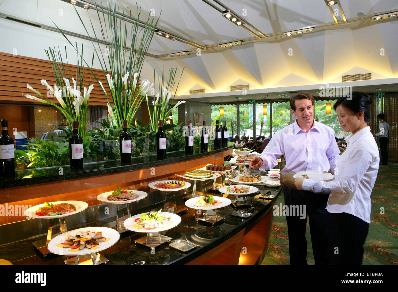 two guests from different cultures taking food in hotel restaurant ...