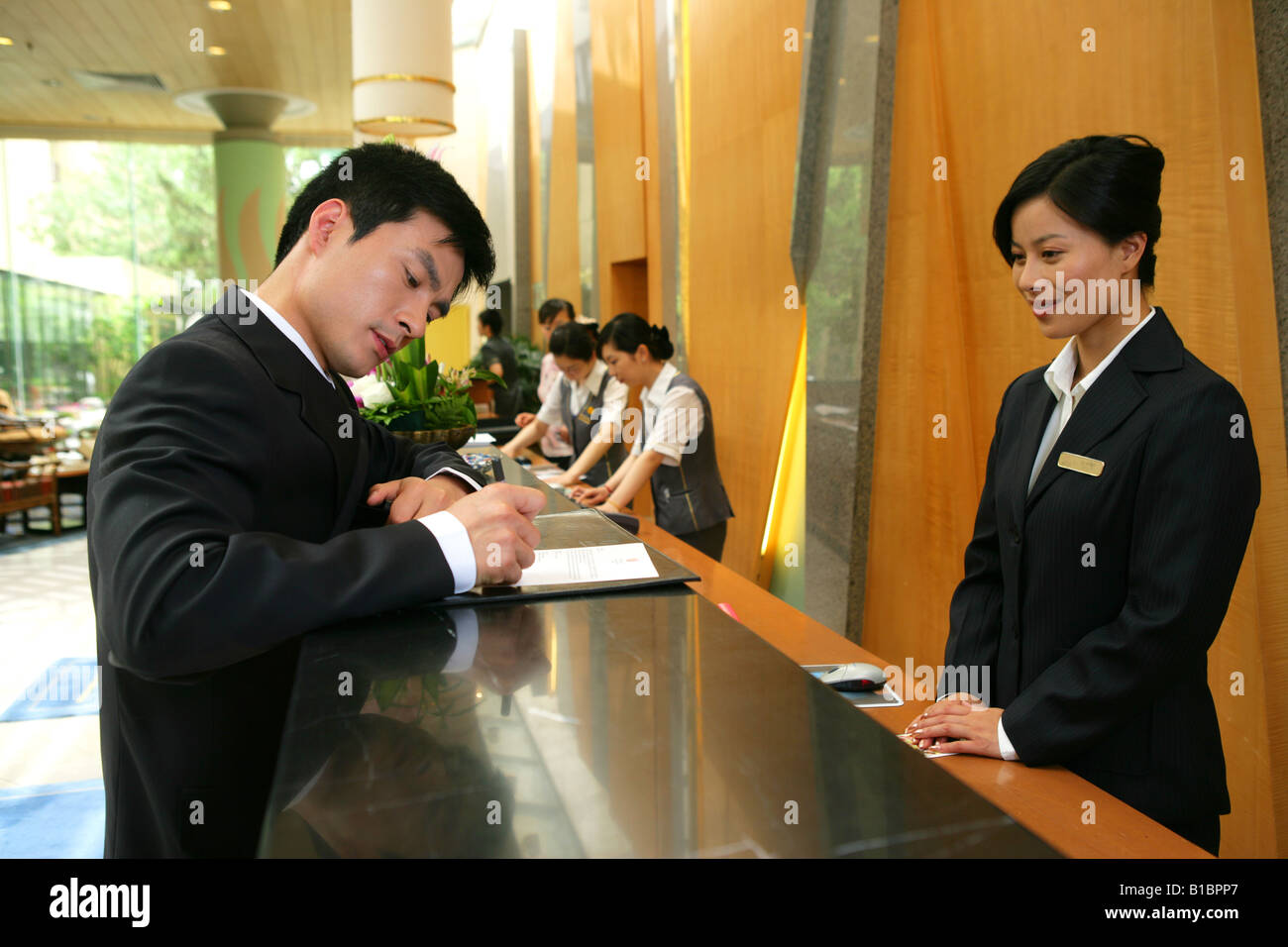 businessman signing at hotel reception Stock Photo - Alamy