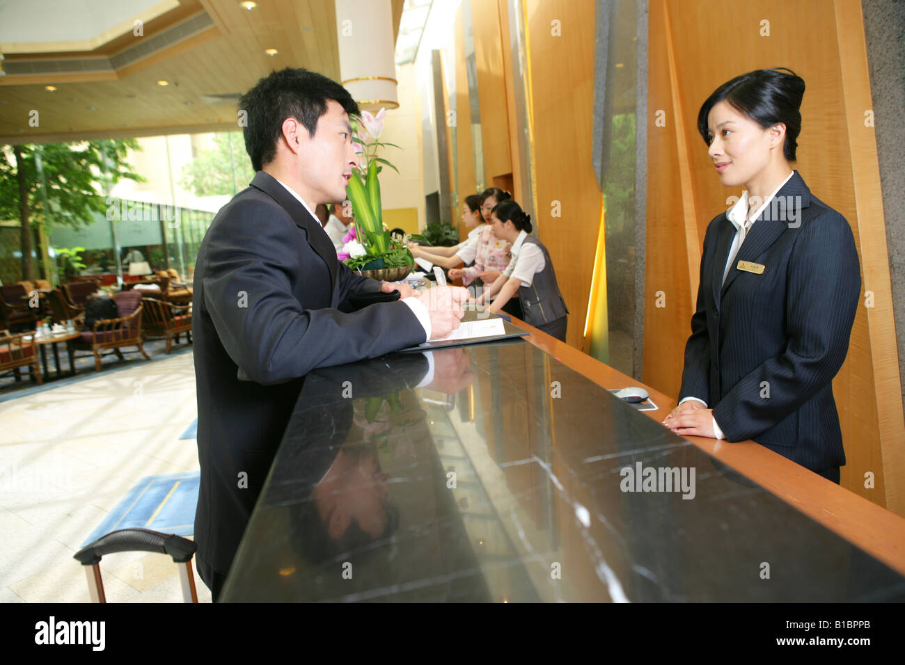 businessman signing at hotel reception Stock Photo - Alamy