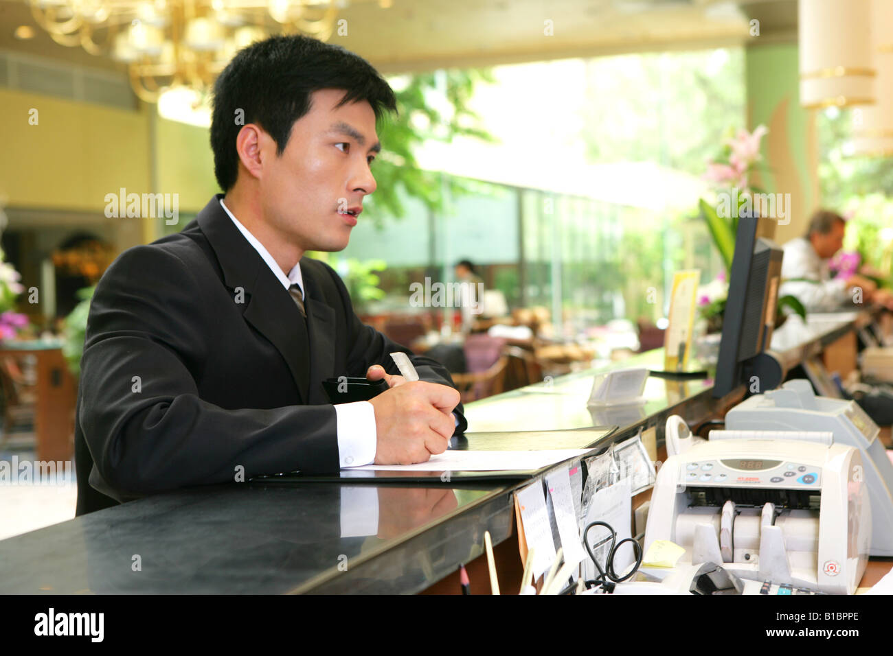 businessman signing at hotel reception Stock Photo - Alamy