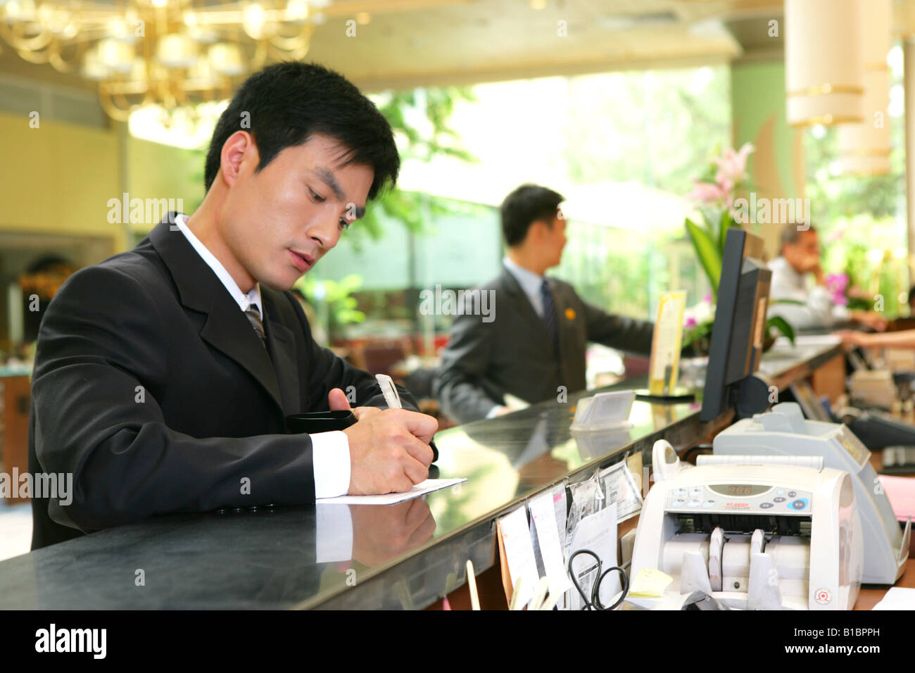 businessman signing at hotel reception Stock Photo - Alamy