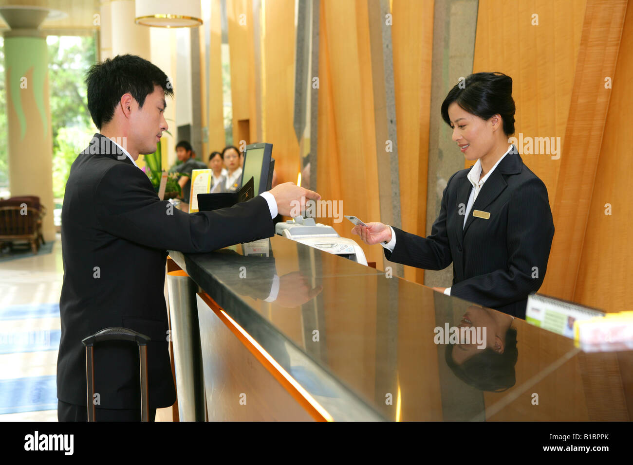 businessman using smart card at hotel reception Stock Photo - Alamy