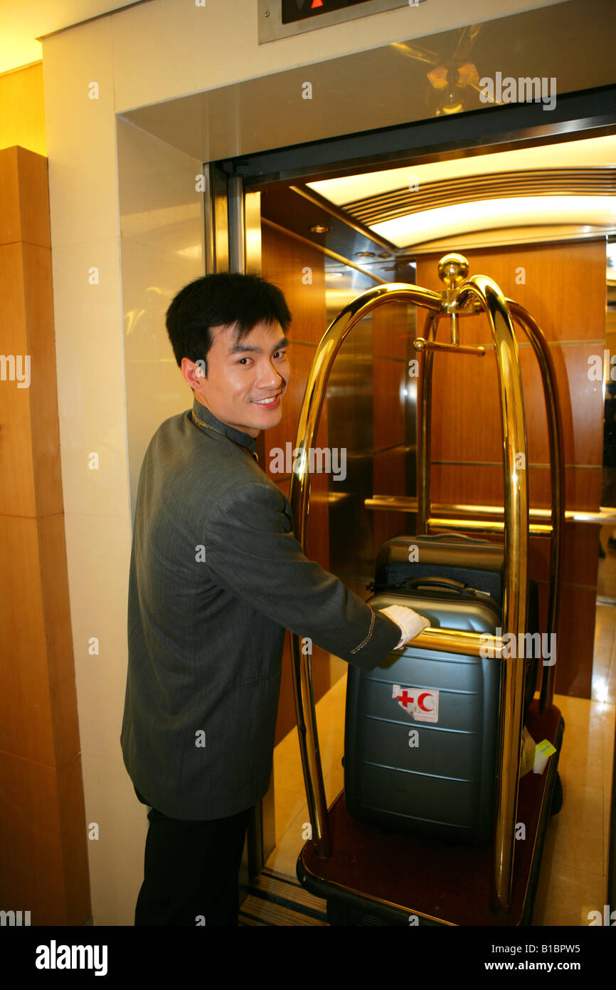 bellhop pushing luggage cart into elevator Stock Photo - Alamy