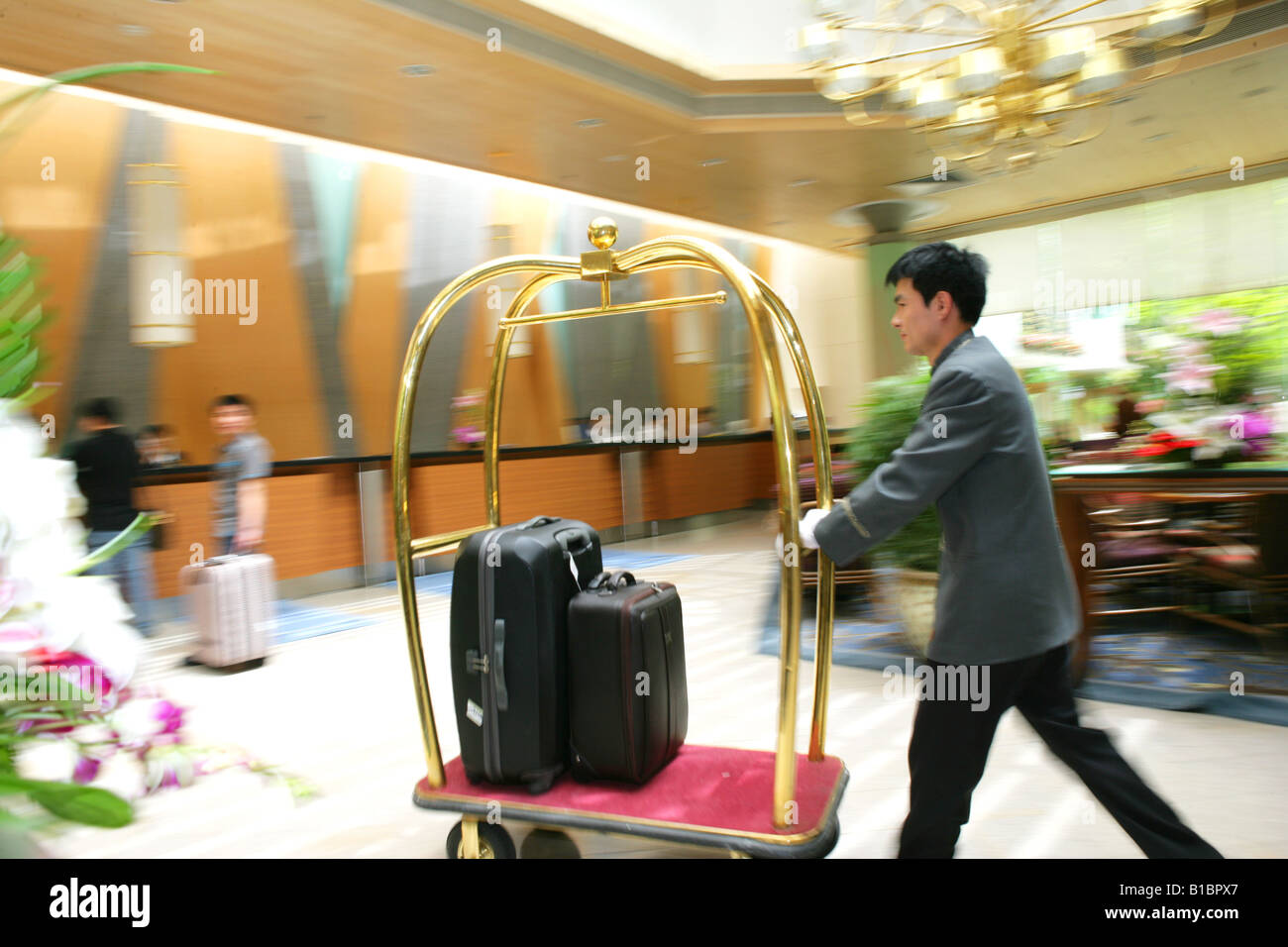 bellhop pushing luggage cart Stock Photo - Alamy