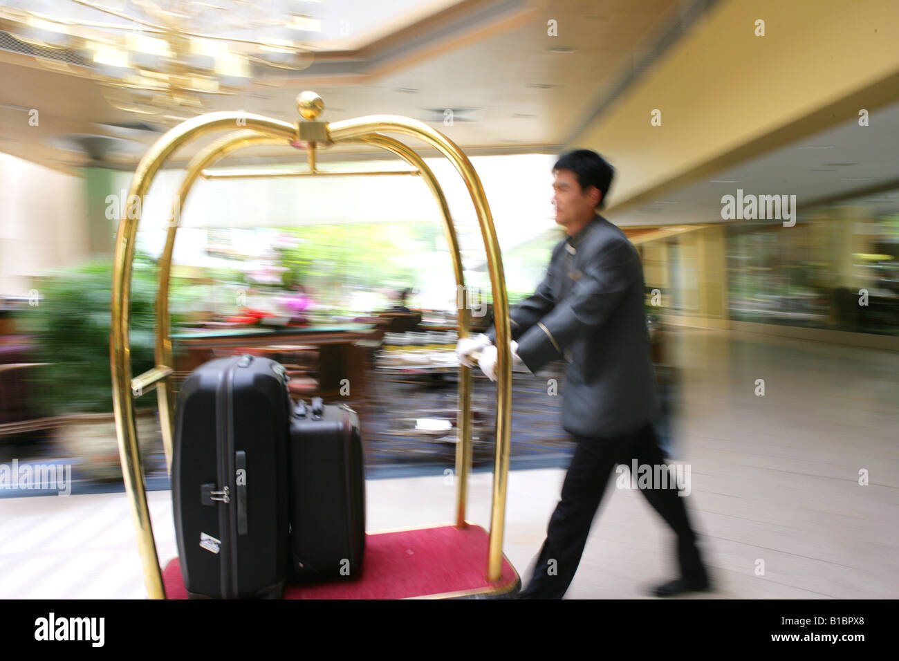 bellhop pushing luggage cart Stock Photo - Alamy