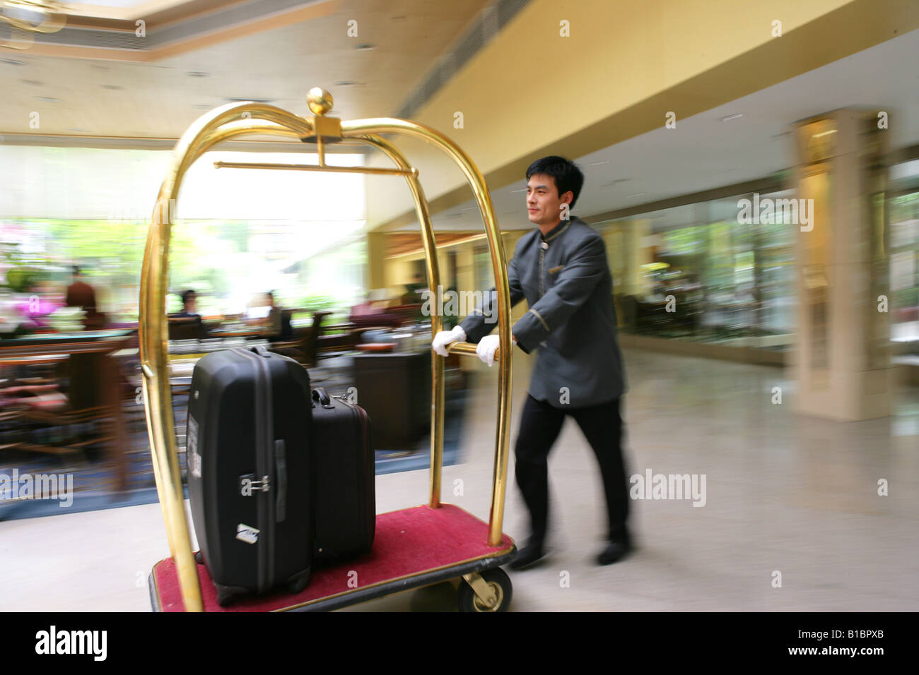 bellhop pushing luggage cart Stock Photo - Alamy