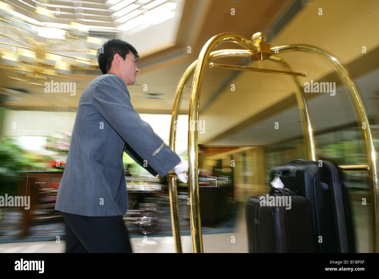 bellhop pushing luggage cart Stock Photo - Alamy