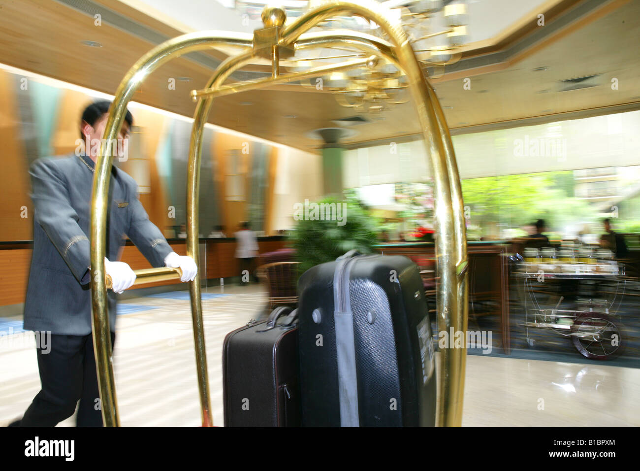 bellhop pushing luggage cart Stock Photo - Alamy