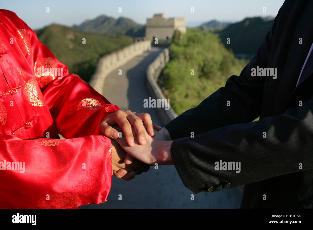 Chinese traditional man and caucasian businessman handshaking on Great ...
